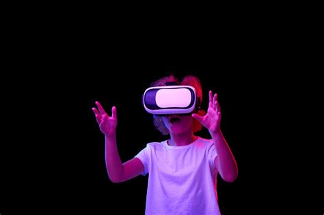 네온 라이트의 어두운 배경에 고립 된 가상 현실 헤드셋에서 3d 기술을 즐기는 흰색 티셔츠를 입은 학창 소녀 6 7 살에 대한 스톡 사진 및 기타 이미지 Istock