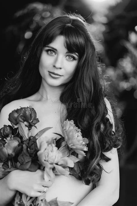 An Beautiful Woman With Long Hair And Bare Shoulders And A Bouquet Of Peonies Stock Image