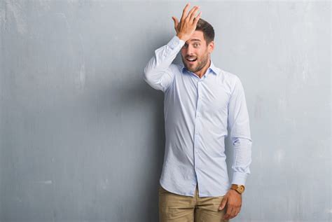 실수에 대 한 머리에 손으로 놀된 우아한 셔츠를 입고 회색 그런 지 벽에 잘생긴 젊은 사업가 기억 오류 깜 빡 나쁜 메모리 개념
