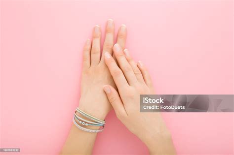 밝은 분홍색 테이블 배경에 젊은 성인 여성 손목에 팔찌 파스텔 색상 아름다운 손질 손 부드러운 터치 근접 촬영 관점 샷 하향