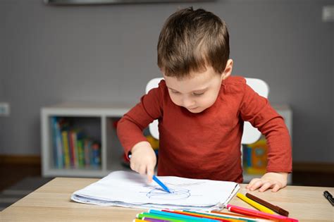 두 살짜리 귀여운 어린 소년이 집 어린이 방의 앨범에 마커로 그림을 그립니다 어린이를 위한 교육 활동 2 3 살에 대한 스톡