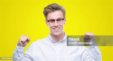 잘생긴 금발 젊은이 축 하 놀라게 하 고 제기 하는 무기와 성공을 위한 놀라게 했 고 눈 우승자 개념입니다 개념에 대한 스톡