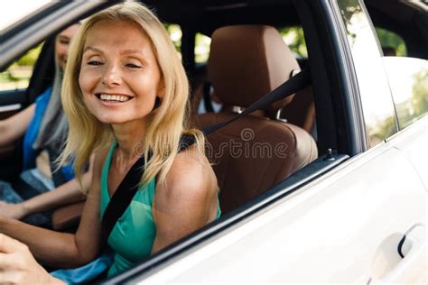 Multiracial Women Laughing And Talking In Car After Practice Stock