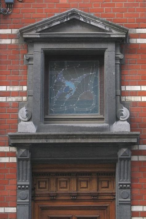 Fenêtre en dessus de porte sous fronton de pierre rue Africaine 56