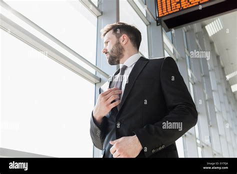 Businessman Adjusting Tie In Airport Stock Photo Alamy