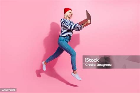 쾌활한 귀여운 소녀 옷을 입은 줄무늬 셔츠 점프 문자 메시지 현대 장치 고립 된 분홍색 배경의 전체 길이 사진 고풍스런에 대한 스톡 사진 및 기타 이미지 Istock