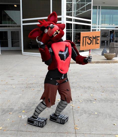 A Person In A Costume Holding A Sign That Says Its Me On The Sidewalk