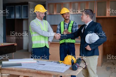 다민족 엔지니어가 서류 작업 및 평면도 도면 계약 및 계약 개념에 대한 비용 추정을 위해 거래 및 측정에 대해 브레인스토밍합니다 가리키기에 대한 스톡 사진 및 기타 이미지
