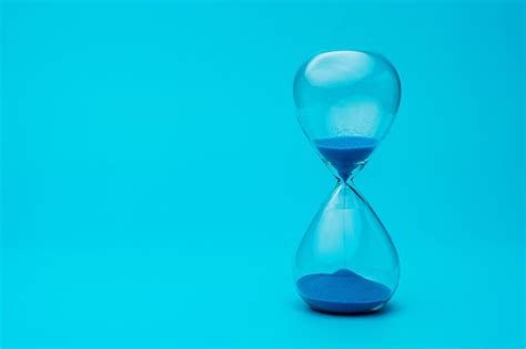 Premium Photo Hourglass With Blue Sand On Blue Background