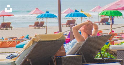 Woman In Blue Bikini Lying On Yellow Sun Lounger On Beach During