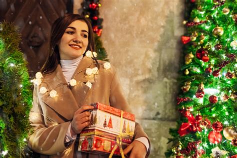 크리스마스 새해 개념입니다 선물 상자를 들고 장식 된 나무로 도시 거리에서 친구를 기다리는 여성 홀리데이 12월 31일에 대한 스톡 사진 및 기타 이미지 Istock