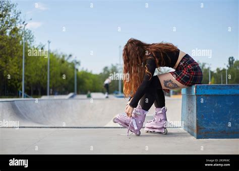 Cool Young Skater Female Putting On Aggressive Inline Skates In A