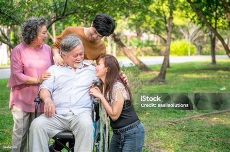 공원에 그의 가족과 함께 수석 남자입니다 중국 늙은이 휠체어와 그의 수석 중국 아내 그랜드 아들 및 딸 함께 휴식 서로 얘기