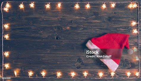 소박한 나무 배경 위에 산타 클로스 모자와 함께 크리스마스 빛 노란색 크리스마스 또는 새 해의 개념 0명에 대한 스톡 사진 및 기타 이미지 Istock
