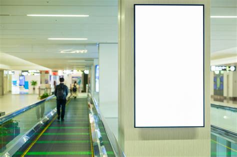한 남자가 표지판을 들고 에스컬레이터를 걸어가고 있다 사진 Unsplash의 무료 공항 이미지