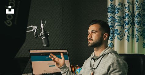 회색 스웨터를 입은 남자가 노트북 컴퓨터 앞 의자에 앉아 있다 사진 Unsplash의 무료 스튜디오 이미지