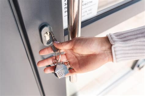 Premium Photo A Womans Hand Opens The Door With A Key On Which The