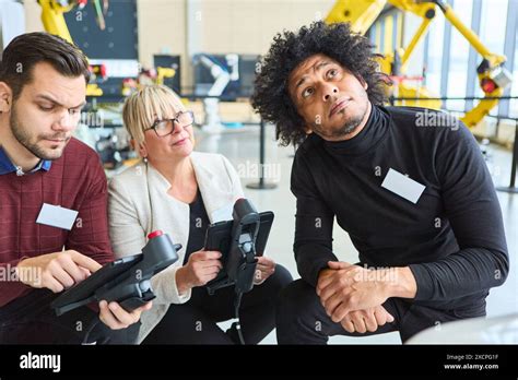 Engineers Collaborating While Programming Robotic Machinery In An