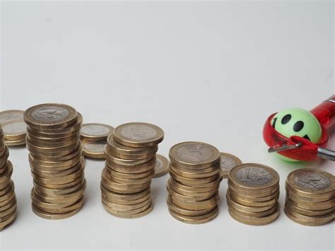 Premium Photo A Toy Robot Sits In A Row Of Coins With A Green Bug On