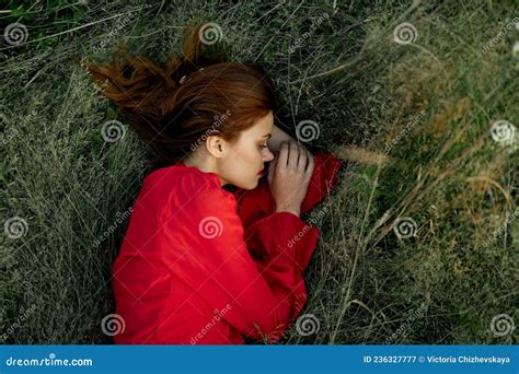 Pretty Woman In Red Dress Lies On The Grass Sun Summer Nature Stock