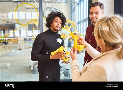 Group Of Engineers Collaborating On Robotics Development Focusing On