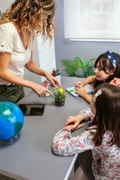 Professora De Sexo Feminino Mostrando Planta De Pansos Para Seus Alunos