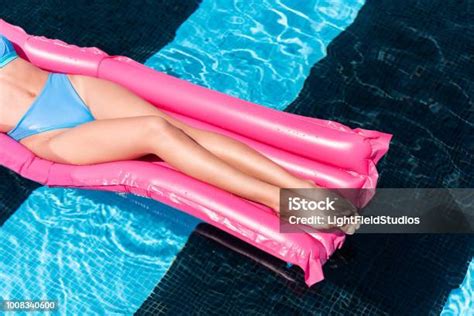 수영장에서 핑크 풍선 매트리스에 여자의 낮은 섹션 보기 다리 신체 부분에 대한 스톡 사진 및 기타 이미지 다리 신체 부분