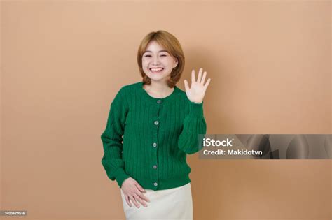 안녕하세요 매력적인 여성의 초상화 손을 흔들며 베이지 색 배경에 고립 된 이빨 미소로 카메라에 인사하는 모습 30 34세에 대한