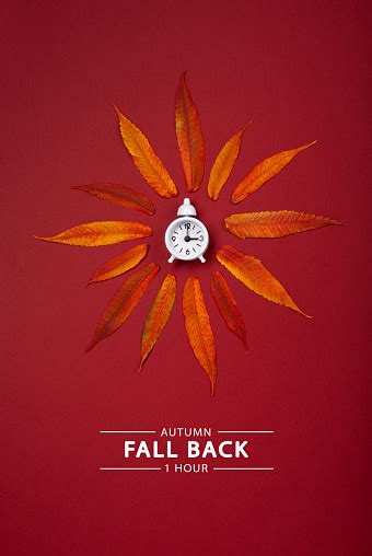 폴백 가을 시간 변경 개념 흰색 알람 시계와 빨간색 배경에 오렌지색 가을 잎 Fall Back Short Phrase에 대한