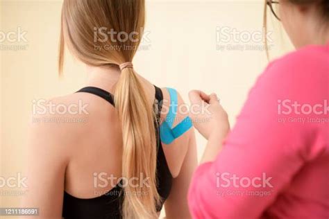 여성 환자의 어깨와 등에 키네시오 테이프를 적용하는 물리 치료사 운동학 물리 치료 재활 개념 후면 보기 2명에 대한 스톡 사진 및 기타 이미지 Istock