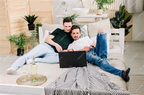 Dwóch Młodych Gejów Leżących Na łóżku I Korzystających Z Laptopa Przystojni Homoseksualiści