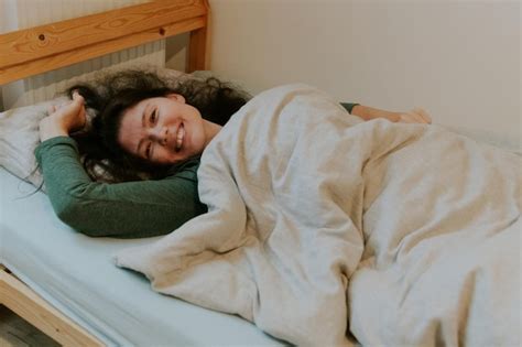 Premium Photo An Adult Girl Wakes Up And Lies In Bed With A Happy Smile