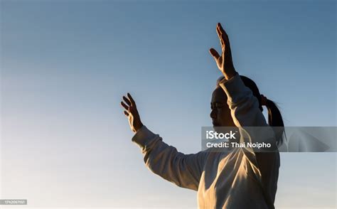 예배에서 손을 들고 있는 여자 기독교 종교 개념입니다 햇빛 하늘 배경에 있는 사람 믿음으로 하나님께 드리는 기독교 여성 기도