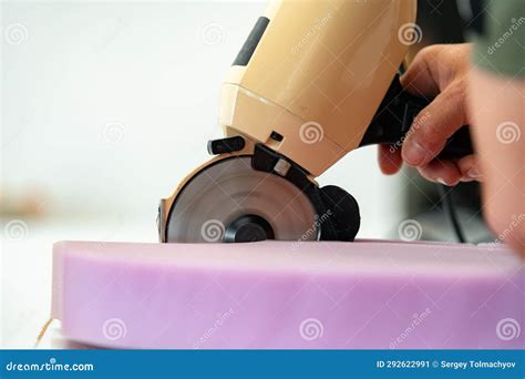Hands Of A Furniture Master Cut A Piece Of Foam With Foam Cutting