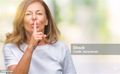 중간 나이 입술에 손가락으로 조용히 하 라는 고립 된 배경 위에 수석 히스패닉 여자 침묵 그리고 비밀 개념입니다 노인에 대한