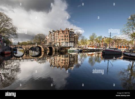The Netherlands Amsterdam Canal Houses And Houseboats In Canal Called
