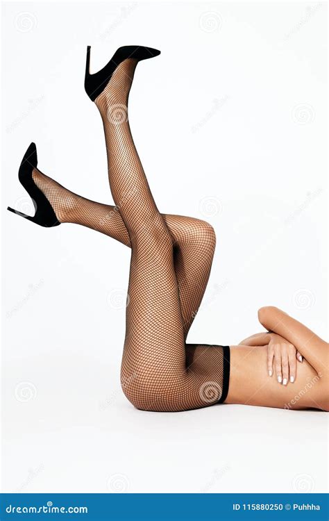 Piernas Femeninas En Medias Negras En El Fondo Blanco Foto De Archivo