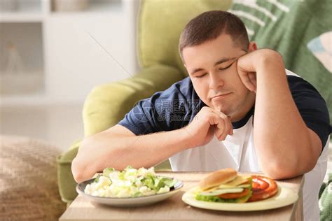 超重男子在家中选择健康食品和高清图片下载 正版图片503793134 摄图网