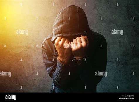 Arrested Computer Hacker And Cyber Criminal With Handcuffs Wearing
