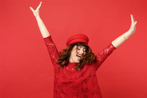 레이스 드레스에 즐거운 행복 한 젊은 여자의 초상화 스튜디오에서 밝은 빨간색 벽 배경에 고립 된 손을 확산 하는 모자 점프 사람들은 진심으로 감정 라이프 스타일 개념입니다