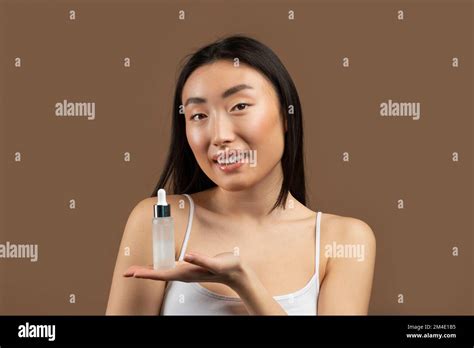 Facial Skincare Concept Asian Lady Showing Facial Serum Bottle Posing
