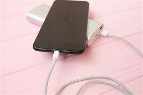 에너지 은행과 충전 전화 파워 뱅크의 필드 깊이입니다 핑크 나무 배경입니다 Usb 케이블에 대한 스톡 사진 및 기타 이미지