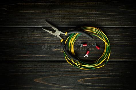 Electrical Wire With Terminals And Pliers On A Vintage Dark Table For