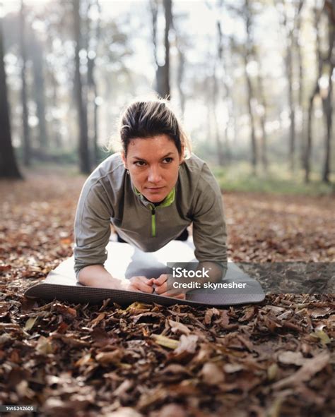 Sweaty Female Athlete Exercising Strength In Plank Position At The Park
