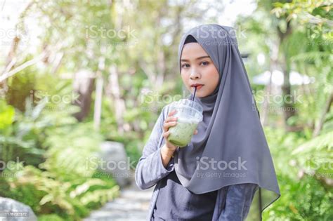 히잡에서 아름다운 무슬림 여성은 배경 자연과 카페에서 녹차 플라스틱 컵을 마시는 녹색에 대한 스톡 사진 및 기타 이미지 녹색