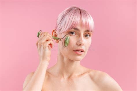 Portrait D Une Jeune Femme Nue Aux Cheveux Roses En Utilisant Un Rouleau Facial Jade Naturel