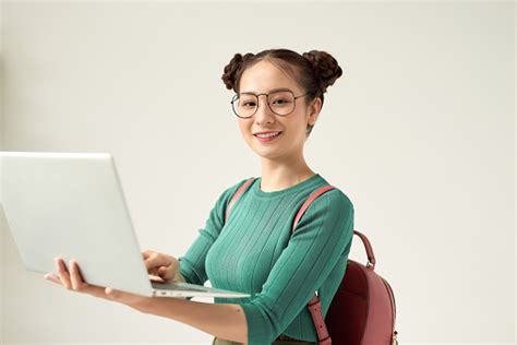 흰색 배경에 고립 된 노트북 컴퓨터를 들고 카메라를보고 웃는 소녀의 초상화 귀여운에 대한 스톡 사진 및 기타 이미지 귀여운