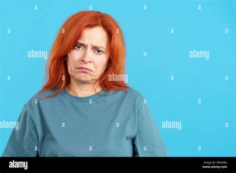 Mature Redheaded Woman Looking At Camera With Sad Expression Stock