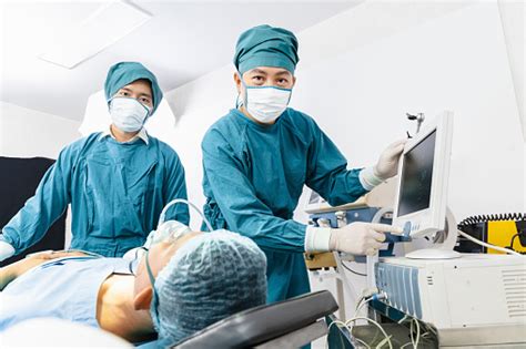 보조 외과 의사는 수술을 준비하기 위해 인공 호흡기 산소 마스크에 환자를 넣어 25 29세에 대한 스톡 사진 및 기타 이미지