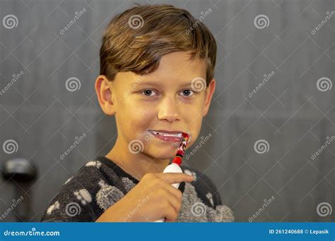 Un Jeune Garçon De Ans Se Brosse Les Dents Avec Une Brosse à Dents électrique Dans La Salle